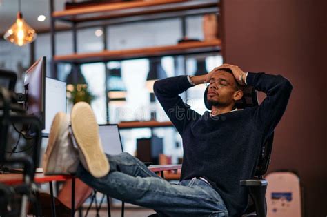 Exhausted African American Programmer Resting At Work Stock Photo