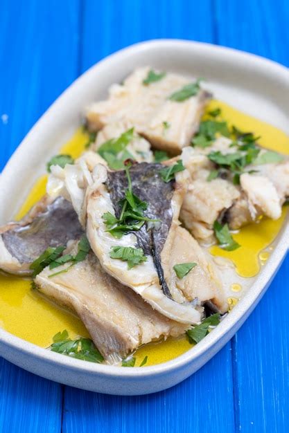 Premium Photo Boiled Cod Fish With Herbs And Olive Oil