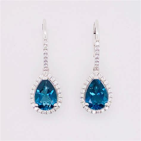 Royal Blue Topaz And Diamond Dangle Earrings In 14 Karat White Gold At