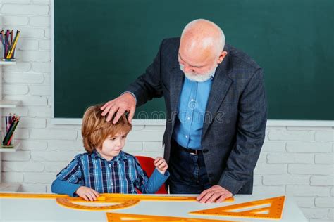 Science Education Concept Elementary School Teacher Giving Female Pupil Support In Classroom