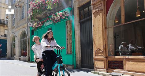 흰 셔츠를 입은 여자 옆에서 자전거를 타고 있는 여자 사진 Unsplash의 무료 보르도 이미지