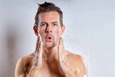 Close Up Portrait Of Emotional American Guy With Wet Body Posing Touching Face Stock Photo