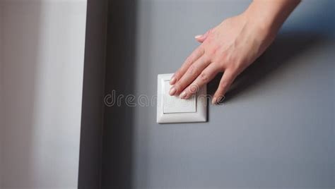 A Beautiful Female Hand Presses The Switch On The Wall Stock Image