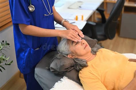 Practitioner Giving Reiki Healing Treatment To Senior Woman