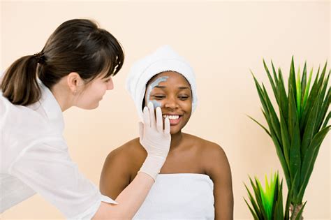 미용사 스파 살롱에서 아프리카 계 미국인 여성의 얼굴에 마스크를 적용 뷰티 및 스킨 케어 컨셉 2명에 대한 스톡 사진 및 기타