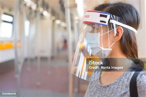 코로나 바이러스 발병으로부터 보호하기 위해 열차 내부에 마스크와 얼굴 방패를 착용한 젊은 아시아 여성 20 24세에 대한 스톡 사진 및 기타 이미지 Istock