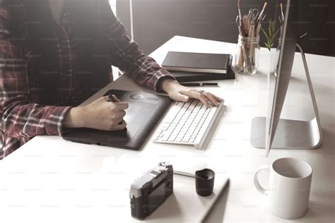 사무실의 책상에서 그래픽 태블릿을 사용하면서 현대 데스크톱 컴퓨터에서 작업하는 여성 그래픽 디자이너 사진 Unsplash의 책상 이미지