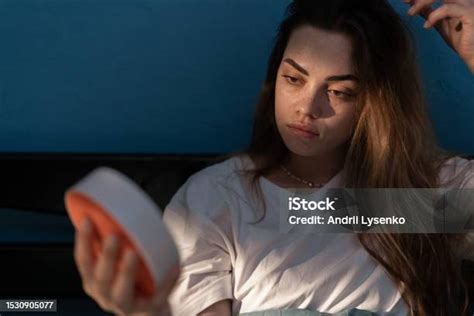 침대에 앉아 시계를 보며 우울한 젊은 여자는 불면증으로 고통받으며 잠을 잘 수 없다 수면 무호흡증 불면증 또는 스트레스 개념 벽 시계에 대한 스톡 사진 및 기타 이미지