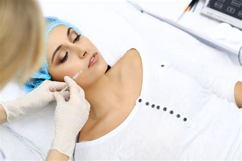 전문 미용사 얼굴 입술에에서 주입을 만들기입니다 젊은 여자는 얼굴 윤곽 또는 확대에 대 한 필러를 주사기를 가져옵니다 얼굴 노화