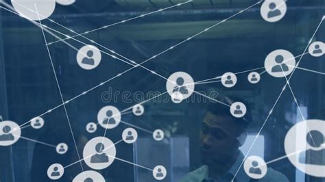 Animation Of Network Of Connections With Icons Over Diverse Business People In Office Stock