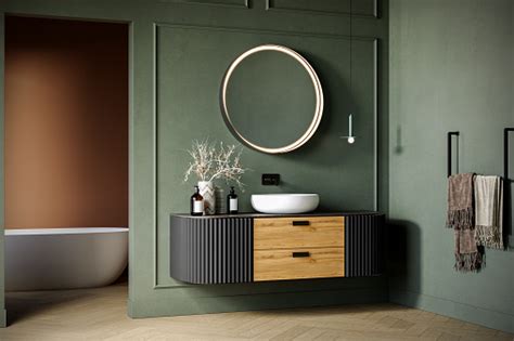 갈색 쪽모이 세공 마룻바닥 녹색과 주황색 벽 화장대 흰색 세면대 타원형 거울 욕조 내부 식물 전면 전망이 있는 현대적인 욕실 인테리어 현대적인 가구를 갖춘 미니멀한 욕실