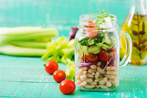 흰 콩 토마토 셀러리 오이 Arugula 붉은 양파와 항아리에 Feta 치즈의 샐러드 다이어트 음식입니다 건강 한 생활양식입니다 스포츠 영양입니다 고기에 대한 스톡 사진 및