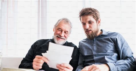 힙스터 아들과 그의 선배 아버지는 집에서 오래된 사진을 보고 있다 실내에서 2 세대 사진 Unsplash의 앉아 이미지