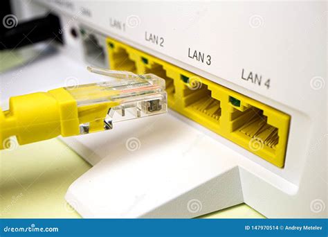 The Yellow Cable With Rj45 Connector Is Inserted Into The Home Router For Internet Stock Photo