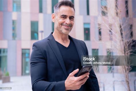 웃는 사업가 스마트폰을 들고 야외에서 카메라를 바라보는 도시 환경 Brand Name Smart Phone에 대한 스톡 사진 및 기타 이미지 Brand Name