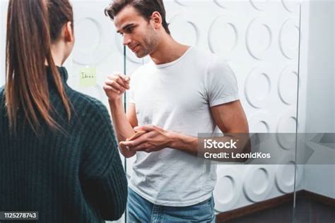 지능형 동료 스티커 유리 참고 벽에 Brainsorming 새로운 사업 계획을 사람들 Stiky 유리 벽 뒤에 서 있는 회의 데 Hr 관리자의 팀 2명에 대한 스톡 사진 및