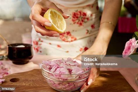 차 장미 꽃잎에 레몬 방울을 더하는 여자 설탕 레몬 차 장미 꽃잎으로 준비하는 미적 수제 소박한 차 장미 잼 건강한 레시피