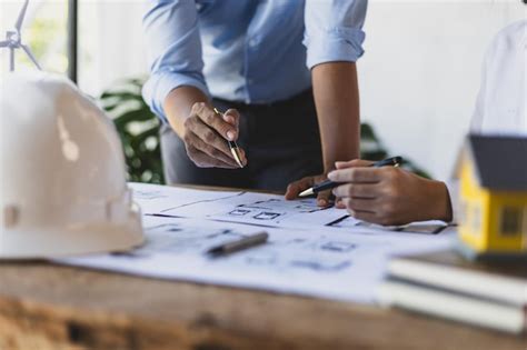 Premium Photo Brainstorming Group Of Architects And Engineers Discuss Building Blueprint