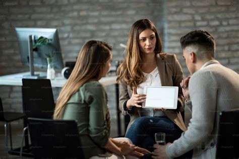 재정 고문은 젊은 부부와 회의를 하고 터치패드로 투자 계획을 보여줍니다 공간을 복사합니다 사진 Unsplash의 세르비아 이미지