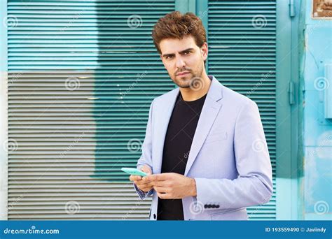 Молодой бизнесмен с голубой костюм с помощью смартфона в городской фон Стоковое Фото