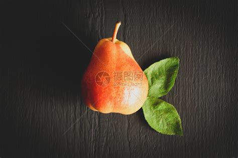 黑色木质背景上的红梨和绿叶高清图片下载 正版图片503966252 摄图网