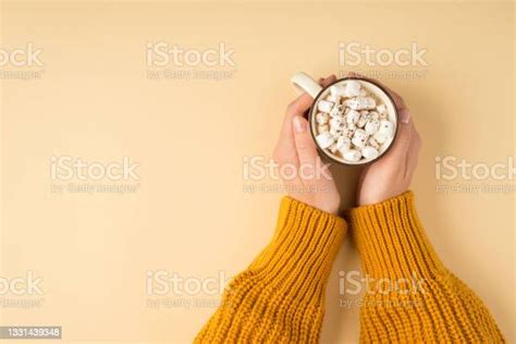 빈 공간이있는 고립 된 밝은 주황색 배경에 마시멜로와 함께 음료 머그잔을 들고 노란색 풀오버에 여성 손의 1 인칭 탑 뷰 사진 초콜릿에 대한 스톡 사진 및 기타 이미지