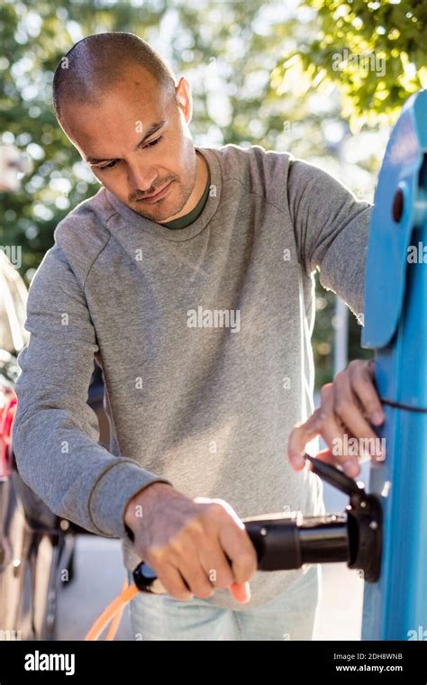 Man Plugging Cable At Electric Station Stock Photo Alamy