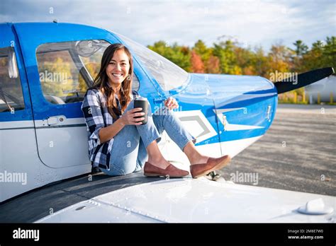 Young Bipoc Female Pilot Having Morning Coffee On Small Plane Wing