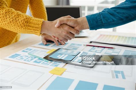 Ux 개발자와 Ui 디자이너가 현대 사무실에서 고객 요약 및 색상 코드와 함께 테이블에 모바일 앱 인터페이스 와이어프레임 디자인에 대해 브레인스토밍합니다 크리에이티브 디지털