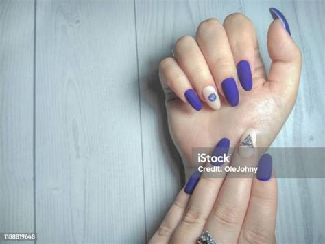 긴 둥근 손톱에 여성의 매니큐어 젤 네일 폴리시 매트 블루 컬러와 삼각형의 눈의 위장 디자인 무광택 은 행성의 디자인과