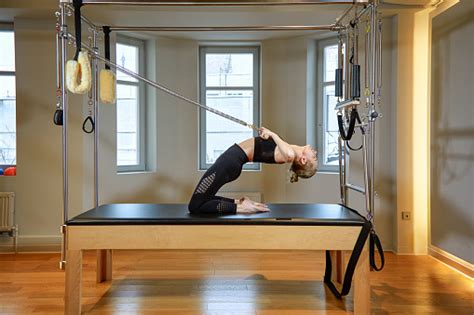 체육관 여자 필라테스 는 개혁 침대 강사 소녀에서 스포츠를 스트레칭 필라테스 를 연습 하는 레오타드를 입고 건강 한 미소 여자