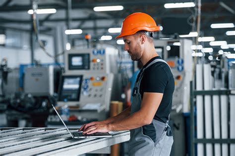 현대 노트북 키보드에 입력합니다 공장에서 산업 노동자 오렌지 하드 모자와 젊은 기술자 경영자에 대한 스톡 사진 및 기타 이미지