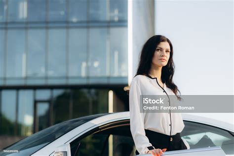 자신감 넘치는 세련된 사업가들이 휴대폰을 들고 차 근처에 서 있는 카메라를 바라보며 공간을 복사한다 교통 개념입니다 25 29