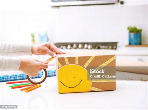 갈색 테이프를 사용하여 귀여운 햇살 디자인의 수제 선물 상자를 봉인하는 여자 배송 행복의 개념 개성 개념에 대한 스톡 사진 및 기타 이미지 Istock