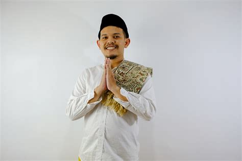 흰 옷을 입은 아시아 무슬림 남성이 라마단과 이드 알 피트르 축제 기간 동안 하얀 배경 위에 서서 인사를 하기 위해 웃고 있다 30 34세에 대한 스톡 사진 및 기타 이미지