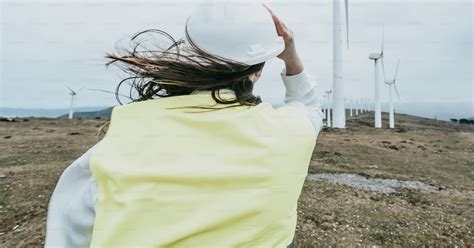 노란 조끼와 흰색 안전모를 쓴 여성이 풍력 터빈 앞에 서 있다 사진 Unsplash의 재생 가능 에너지 이미지