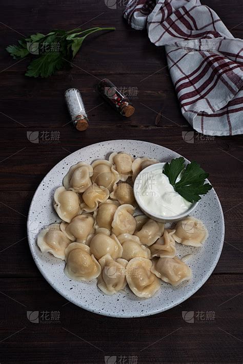 传统的饺子意式馄饨用盘子盛满肉的饺子俄罗斯厨房木质质朴的背景复制空间