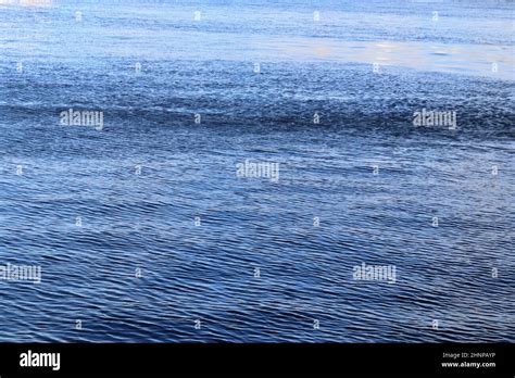 Detailed Close Up View On Water Surfaces With Waves And Ripples And The Sunlight Reflecting At