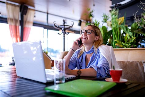 매우 매력적인 젊은 사업가는 카페에서 뜨거운 음료를 즐기고 그녀의 휴대 전화에서 대화에서 몇 가지 사업 계획을 만들고있다 20 29세에 대한 스톡 사진 및 기타 이미지