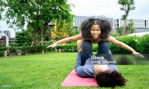 공원에서 요가 운동을하는 귀여운 재미있는 아이 딸과 함께 신중한 아프리카 엄마calm 흑인 어머니와 도시 공원 자연에서 요가를하는 혼합 인종 어린 소녀 명상을 가르치는 엄마
