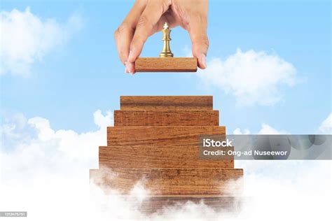 비즈니스 성장 비즈니스 성공 또는 경력 경로 성공 개념 손은 구름 장면에 나무 쌓인 계단에서 멀리 왕 체스와 다음 나무 조각을 들어 올리고있다 개념에 대한 스톡 사진 및