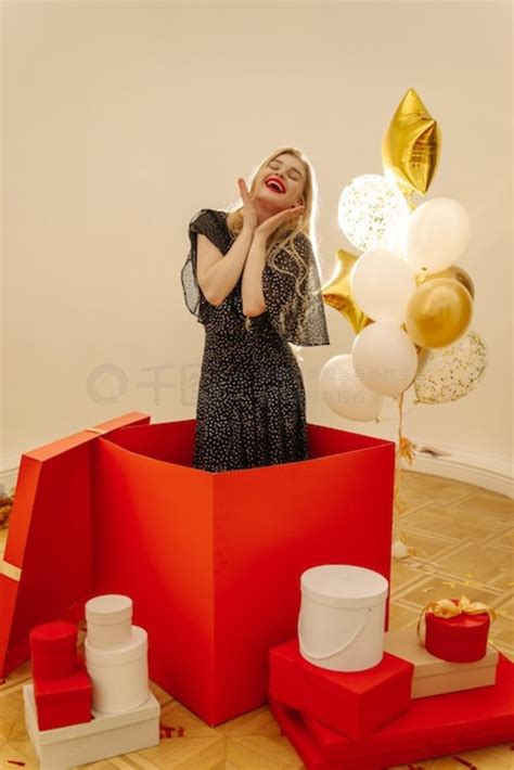 金发女郎高清图片身着黑裙的快乐的白人金发女郎站在大盒子里，周围是礼物和气球娱乐和生活方式概念产品实拍免费下载格式编号51372437 千图网