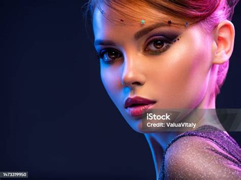 밝은 화장을 한 아름다운 여자의 초상화 보라색 눈 화장으로 여성 얼굴을 클로즈업합니다 얼굴 근처에 보라색 손톱을 가진 예쁘고 섹시한 소녀 짧은 매끄러운 머리를 가진 세련된