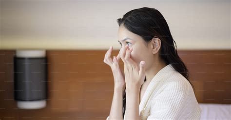 침실에서 얼굴에 보습 크림을 바르는 흰색 목욕 가운을 입은 행복한 아름다운 여성 스킨 케어 및 치료 개념 사진 Unsplash의 건강한 라이프 스타일 이미지