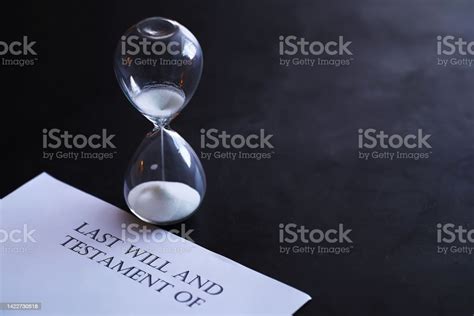 복사 공간이 있는 어두운 테이블 배경에서 카운트다운에서 마감 시간까지 지나가는 시간을 측정하는 모래시계의 전구를 통과하는 모래