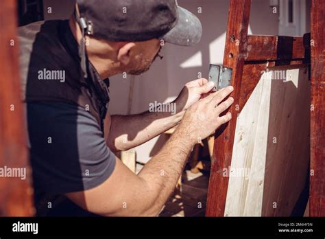 Handyman Placing A Door Hinge In The Wooden Door Frame Home Renovation Stock Photo Alamy