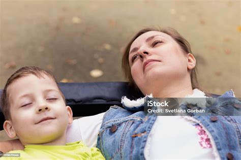 Mom And Son Swing On A Swing At The Playground In The City Park Stock