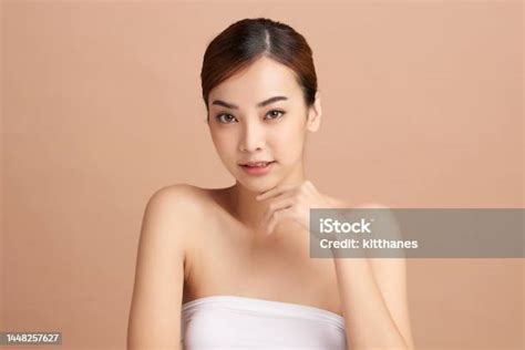 베이지 색 배경에 깨끗한 신선한 피부를 가진 아름다운 젊은 아시아 여성 얼굴 관리 얼굴 치료 화장품 아름다움과 스파 아시아 여성 초상화 20 24세에 대한 스톡 사진 및