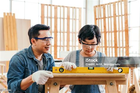 아시아 전문 남성 목수 엔지니어 아빠 청바지 복장에 안전 장갑과 고글을 착용하고 주택 건설 현장에서 수위 측정 통치자를 사용하여