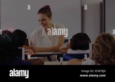 Female Teacher Guiding Students On Tablets In Class Activating Chart